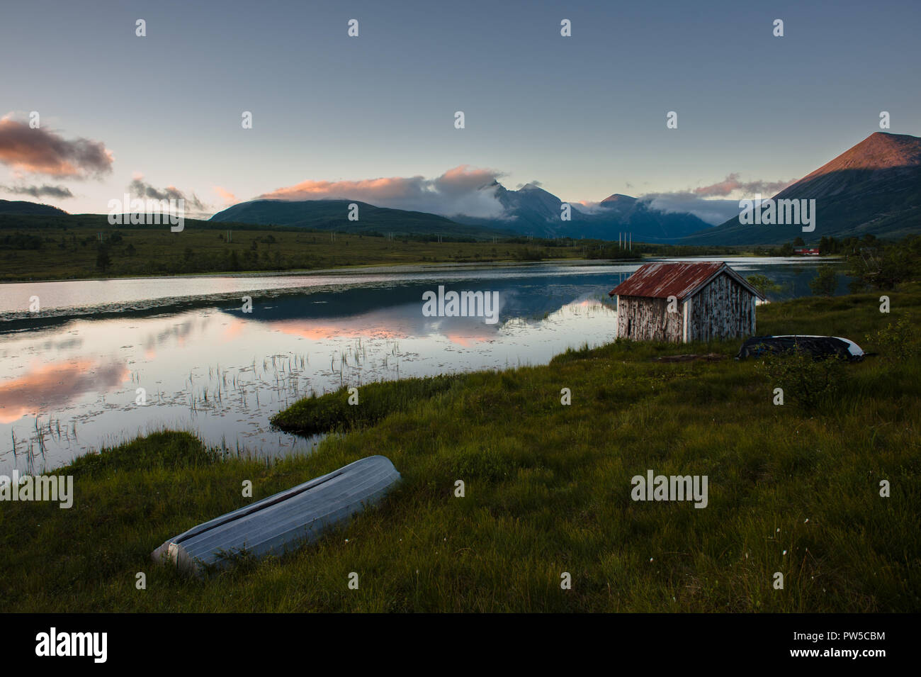 A rural area in Norway, Europe with a boat on the shore and high ...