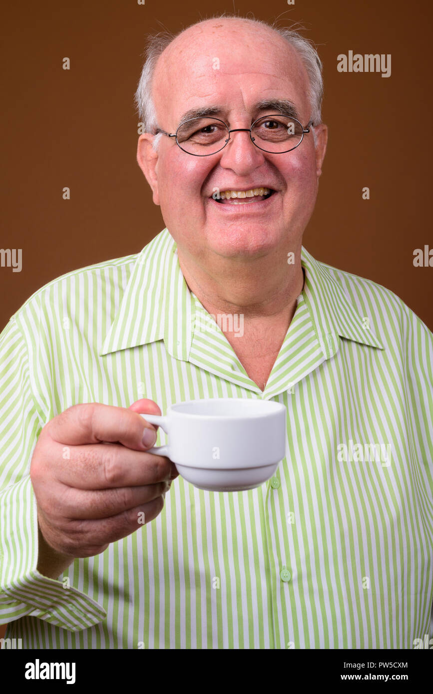 Portrait of overweight senior man holding coffee cup Stock Photo - Alamy