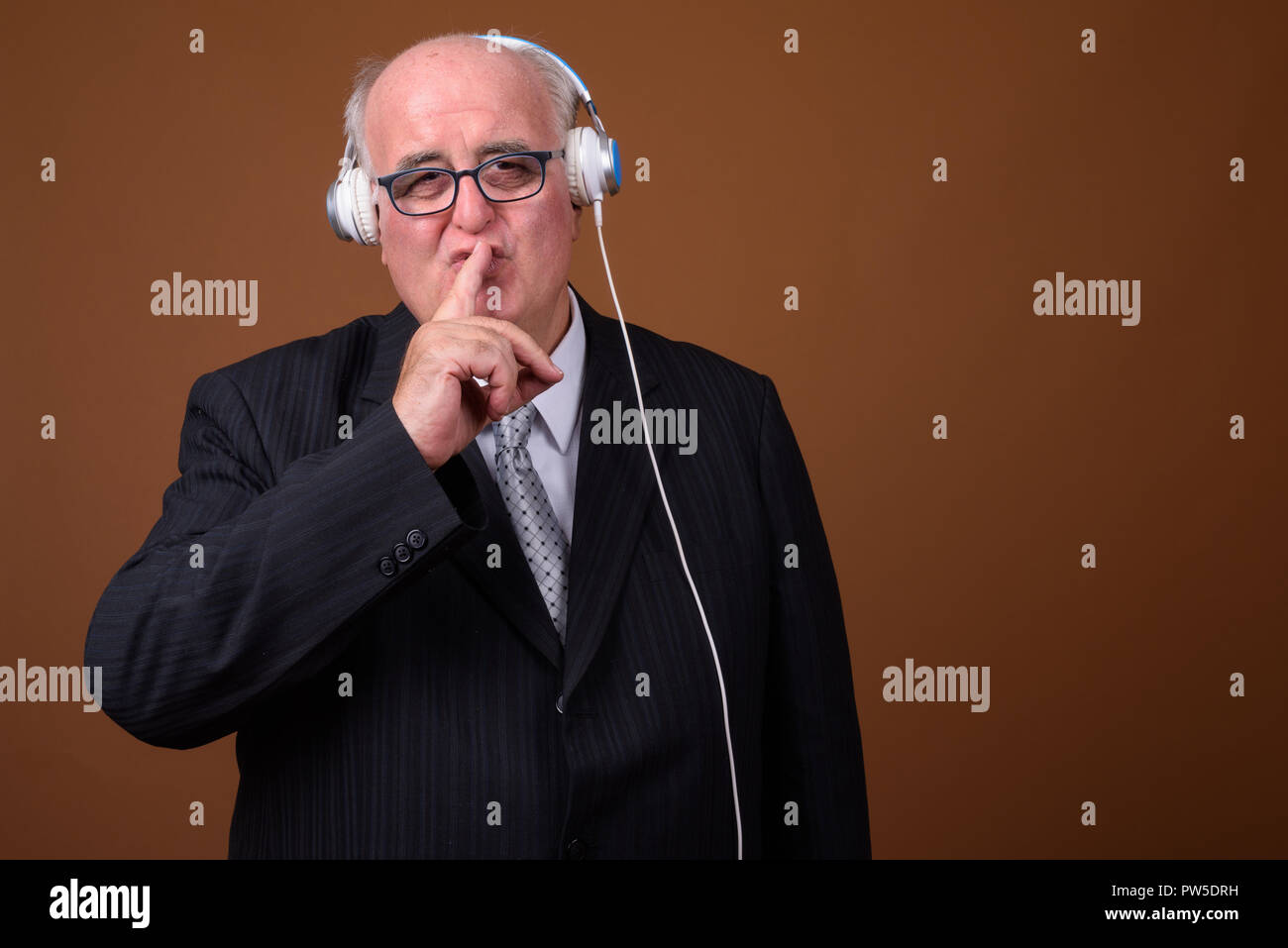 Overweight senior businessman listening music with headphones Stock ...