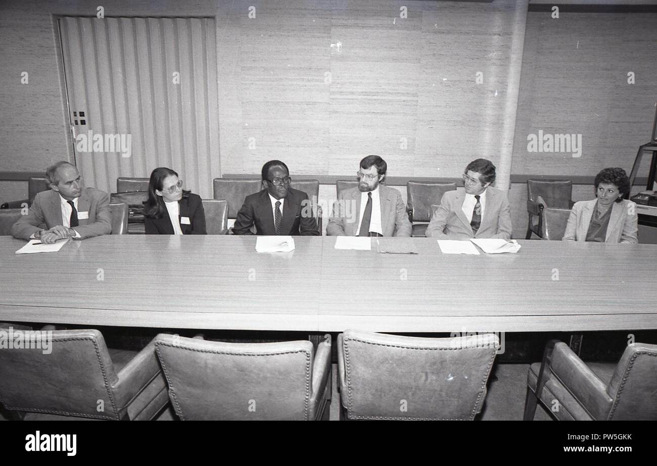 Snapshot of people sitting at a long table Stock Photo - Alamy