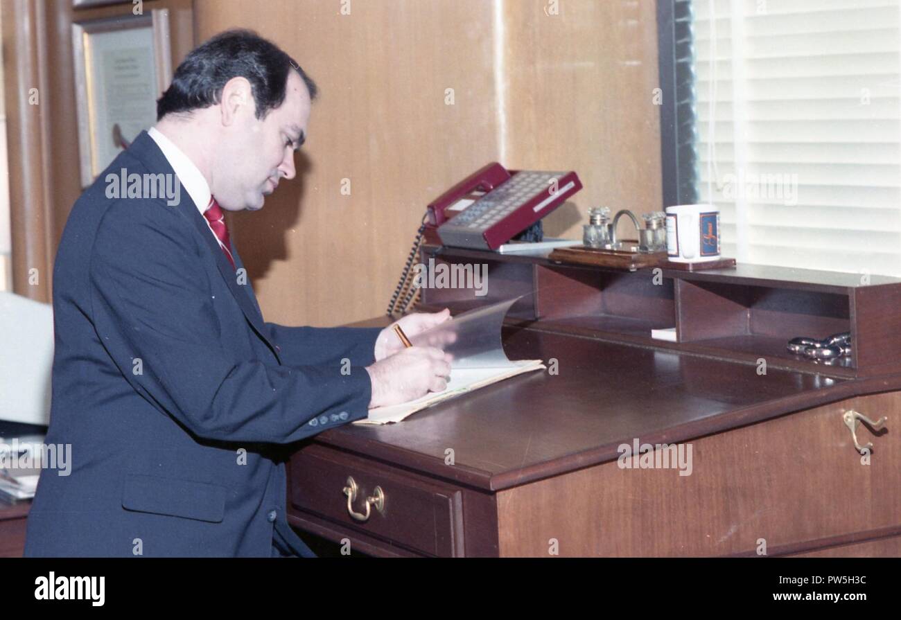 A MAN STANDING WRITING ON SOME PAPERS Stock Photo - Alamy