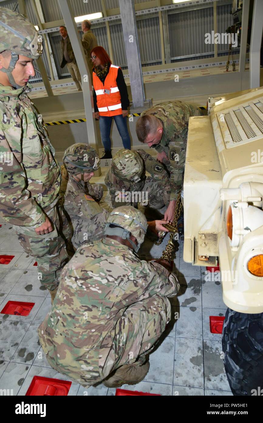 A High Mobility Multipurpose Wheeled Vehicle (HMMWV) is loaded into a C ...
