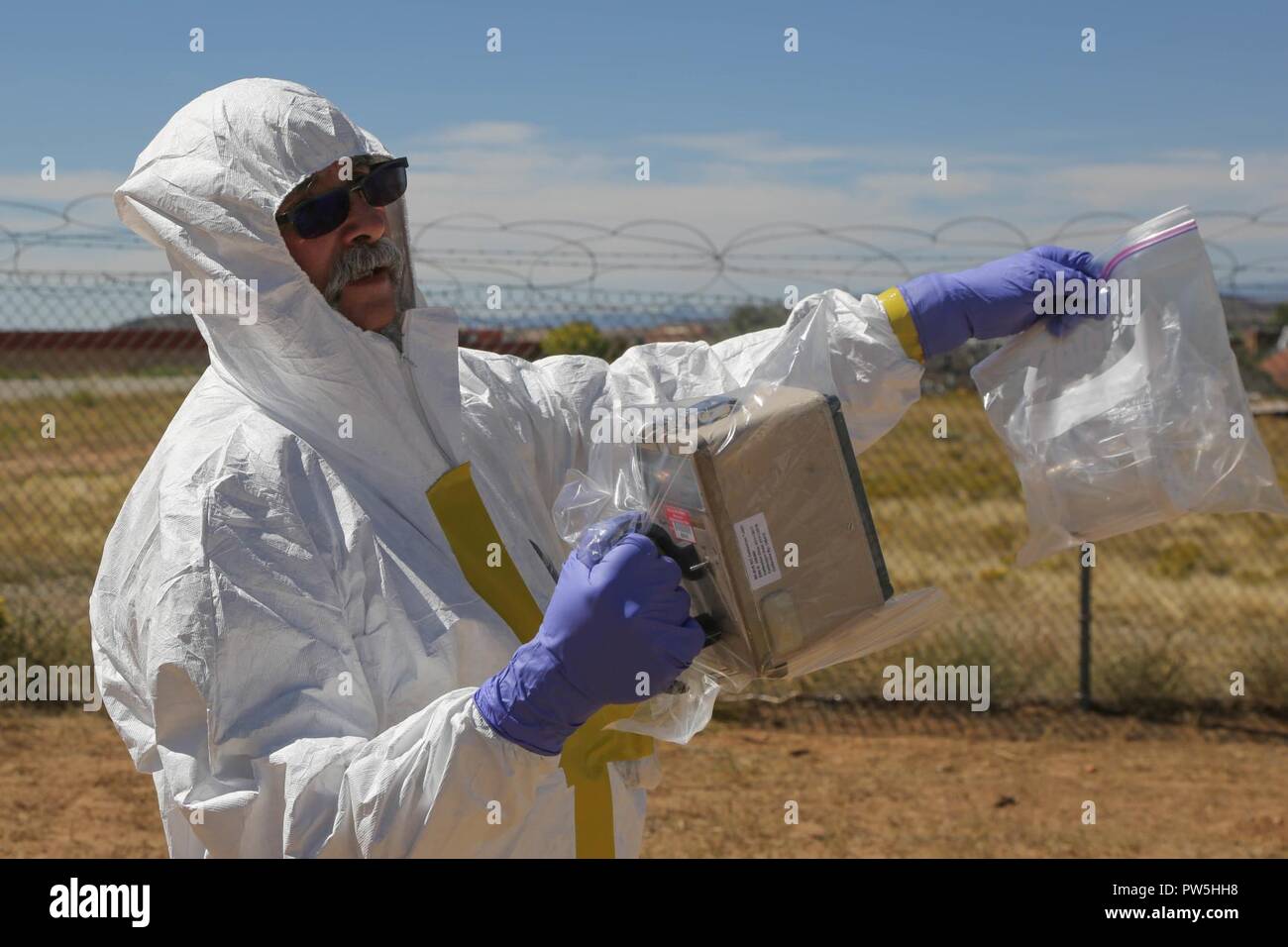 A Department of Energy (DOE) civilian conducts radiation checks using a ...
