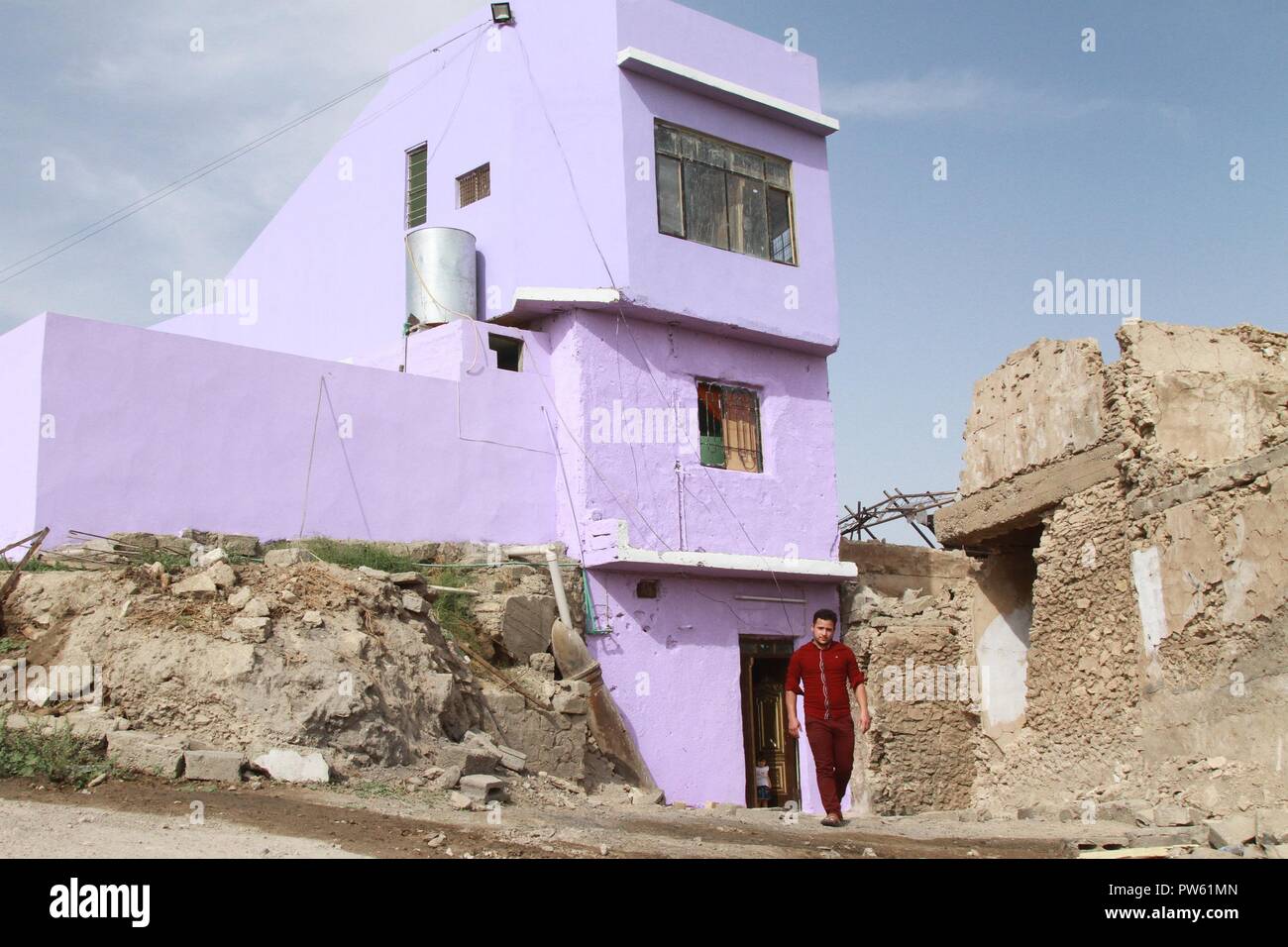 Mosul, Iraq. 12th Oct, 2018. Younis Abu Rajab's son walks out of the ...