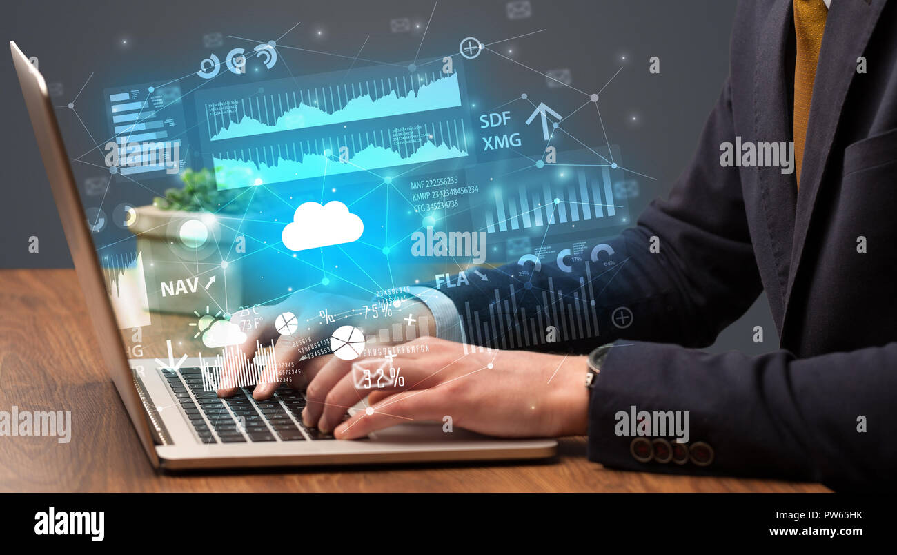 Businessman hand typing on laptop with reports and graphs concept ...