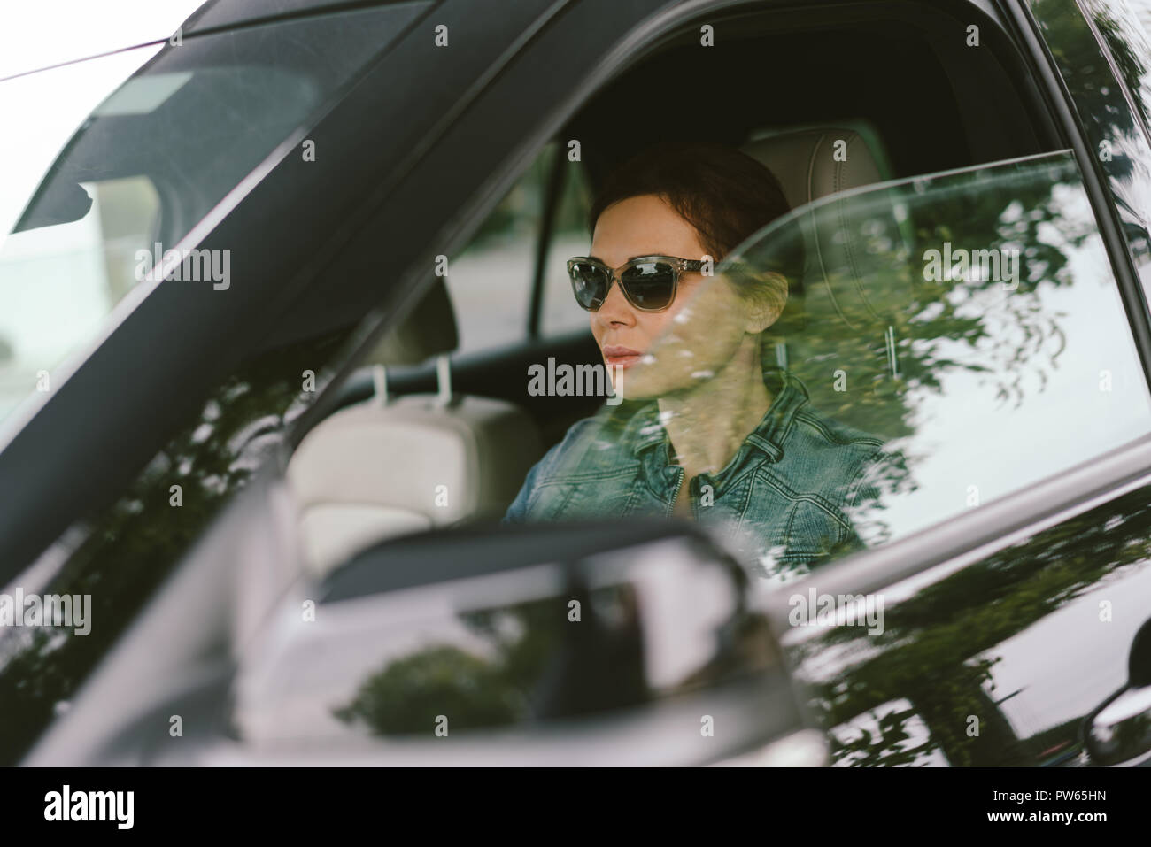 Pretty woman driving car with sunglasses Stock Photo - Alamy