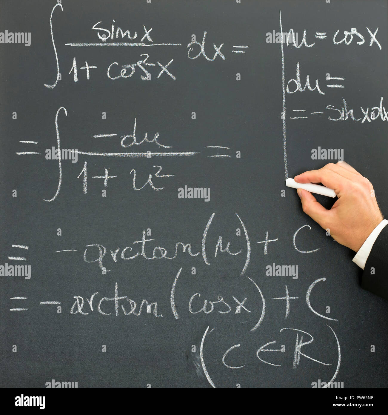 Hand of a businessman writing scientific formula on a blackboard ...