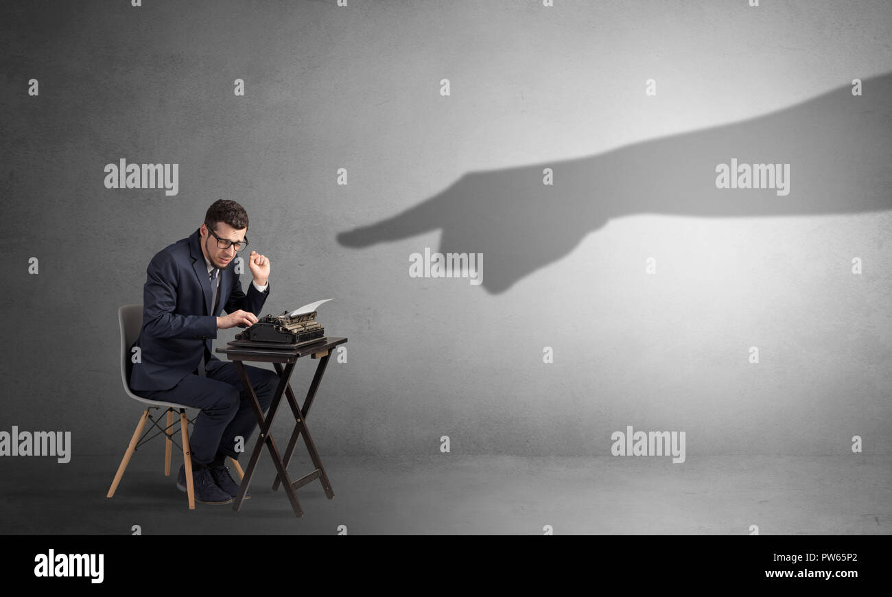 Shadow hand pointing at a small afraid worker Stock Photo - Alamy