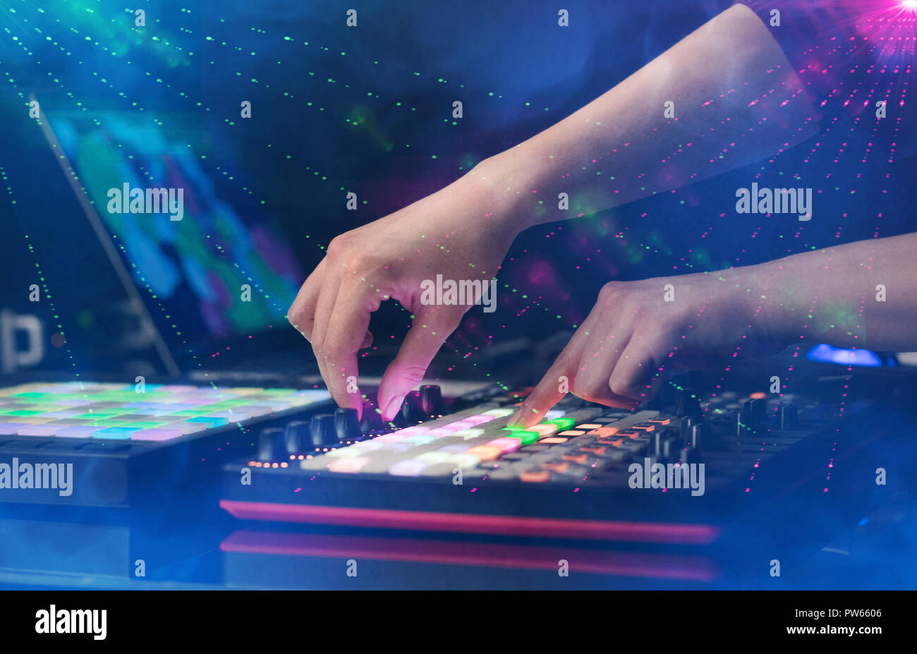 Hand mixing music on midi controller with party club colors around ...