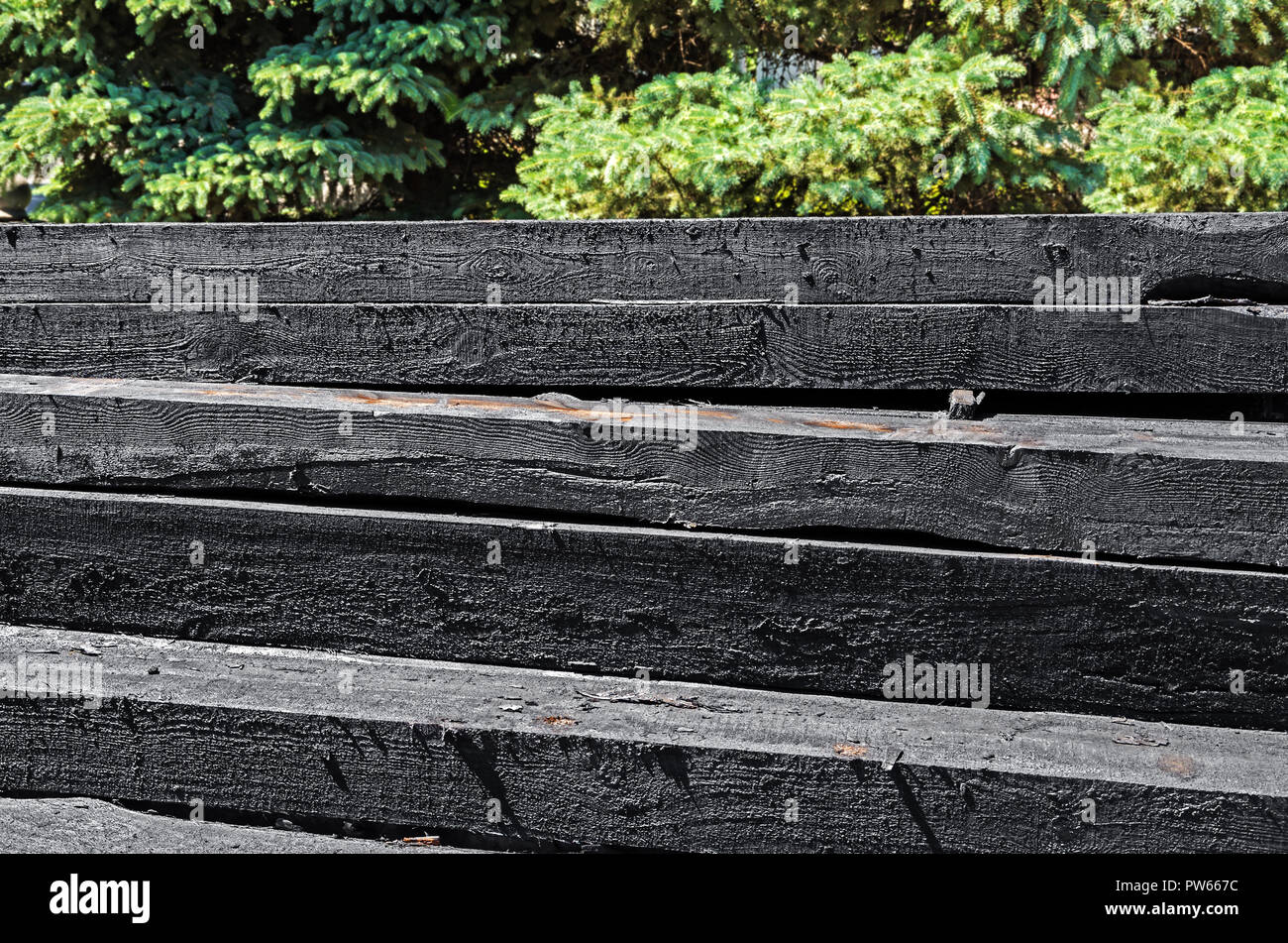 Set of new creosote impregnated wooden sleepers are stacked on each ...