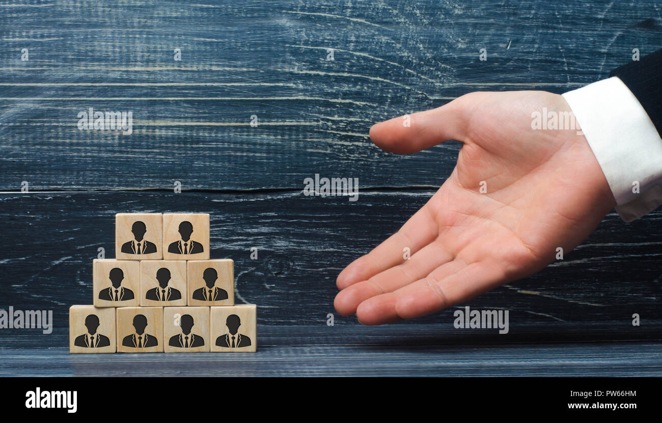 Head hunter shows on a pyramid of cubes with employees. The concept of ...
