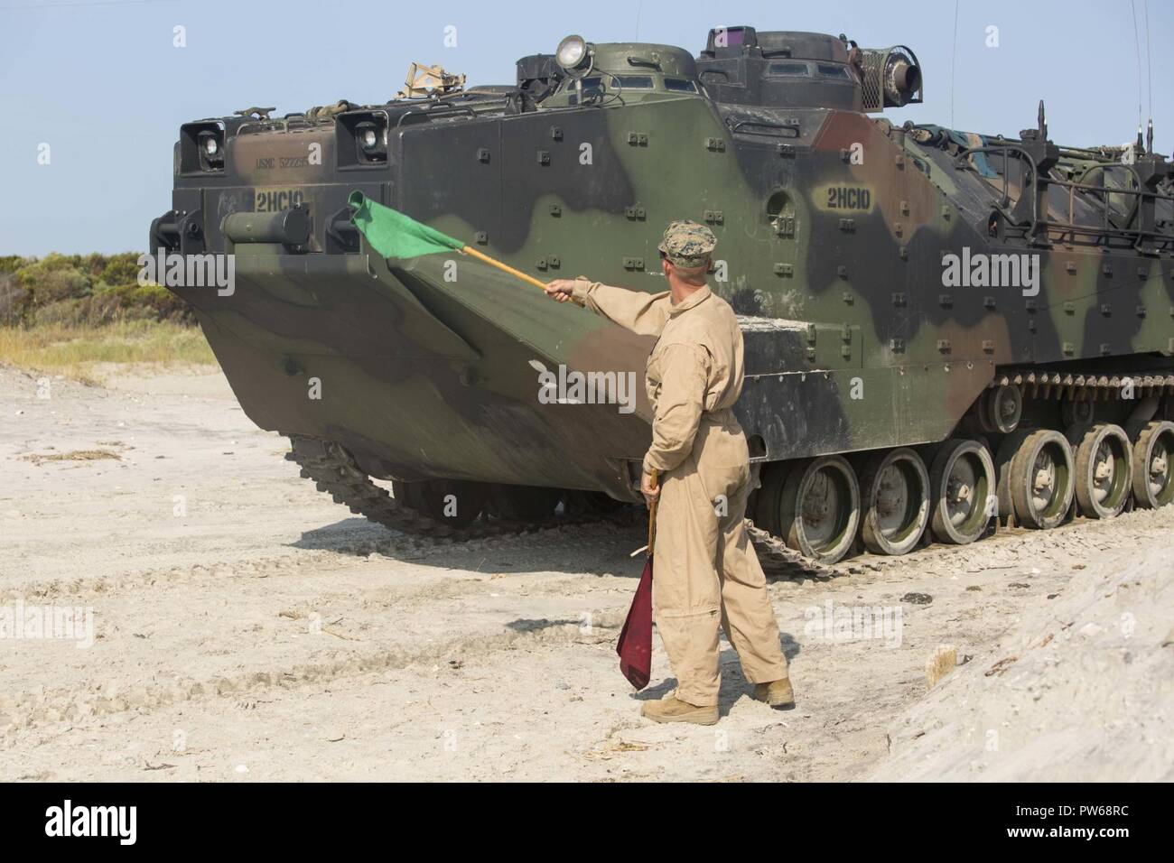 A Marine with 2nd Assault Amphibian Battalion guides vehicles to the ...