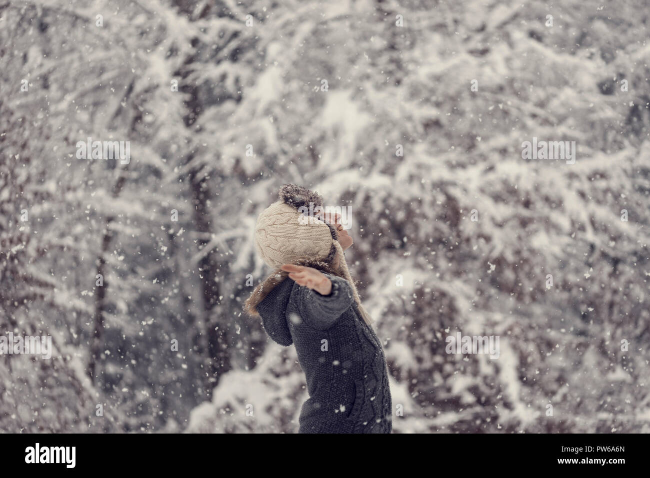 Retro effect faded and toned image of a woman celebrating winter ...
