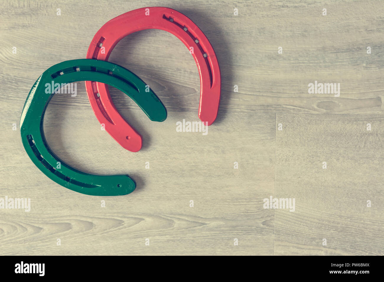 Pair of green and red horseshoes on a wooden desk Stock Photo - Alamy
