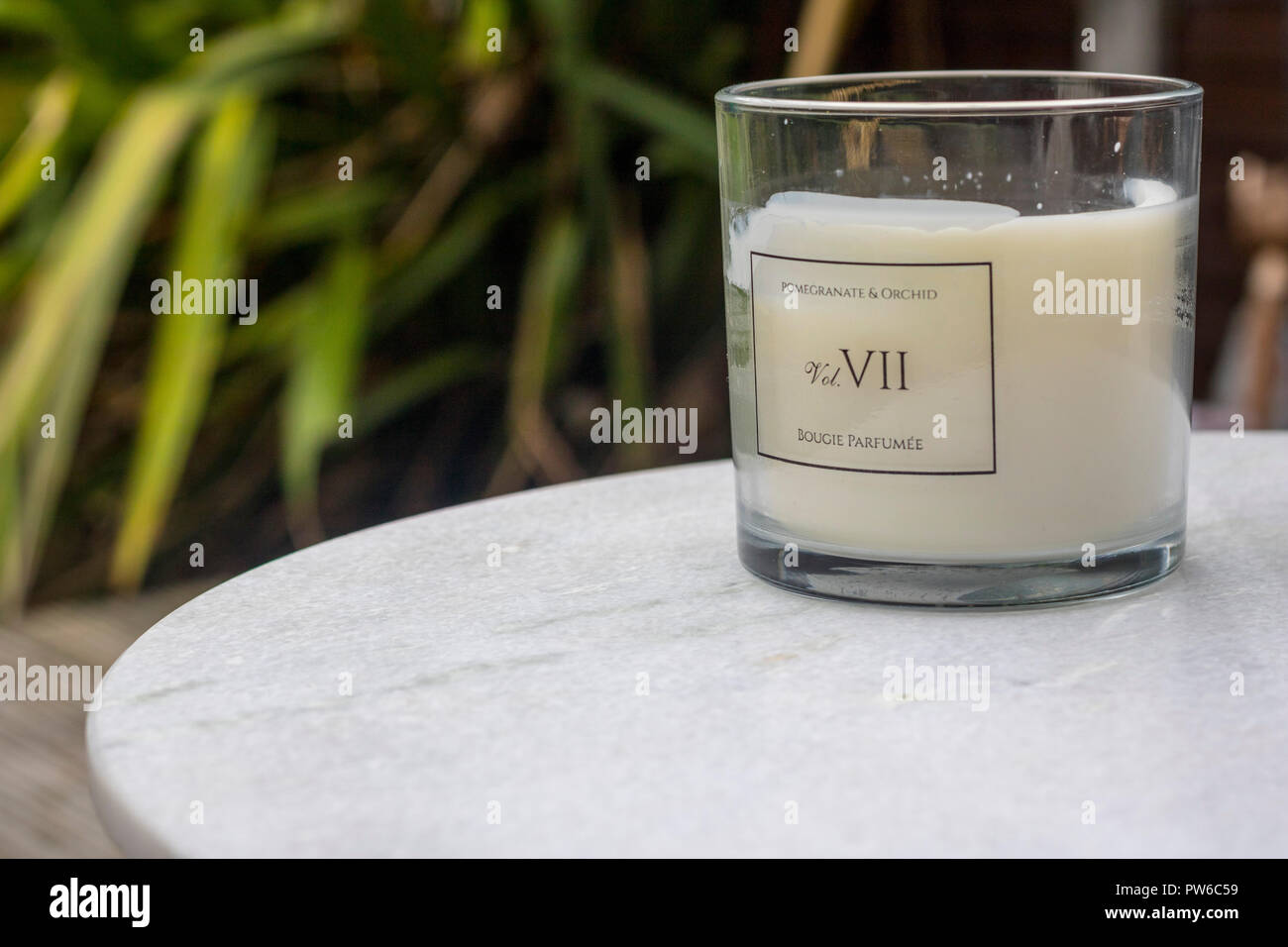 single candle double wicks in a glass jar on a marble table, relaxed ...