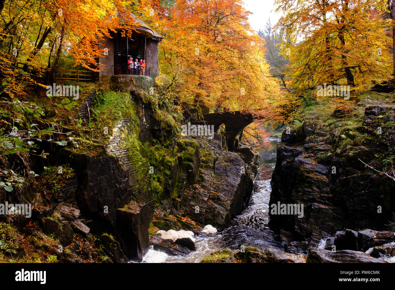 Autumn view of Ossian’s Hall overlooking cascade of Black Linn Falls on ...