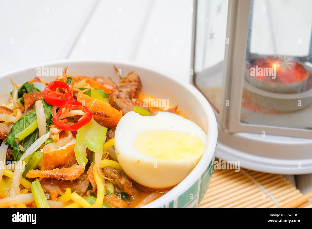 Malay Mee Rebus in the bowl with chopsticks on white table This dish is ...