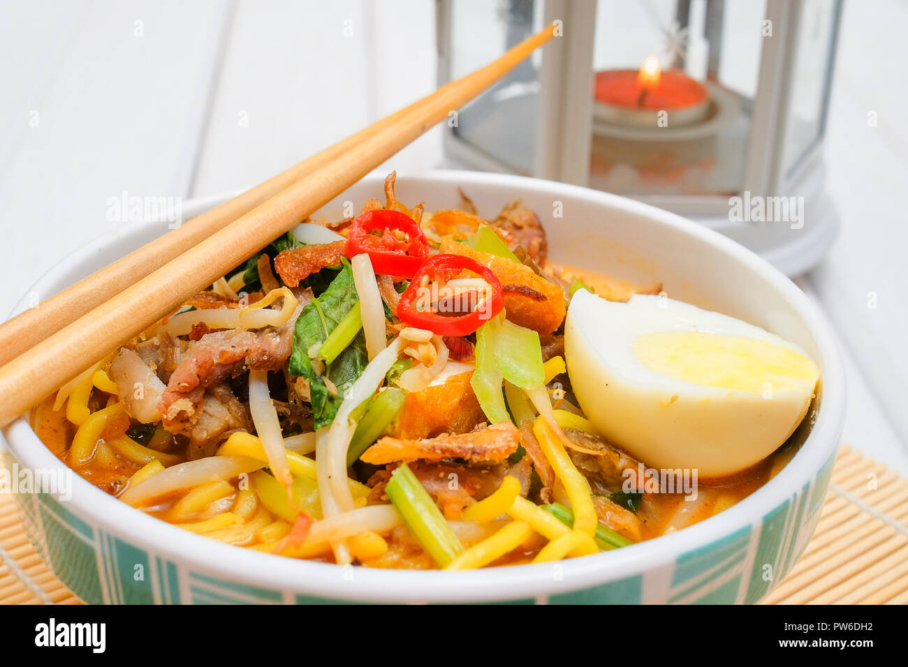 Malay Mee Rebus in the bowl with chopsticks on white table This dish is ...