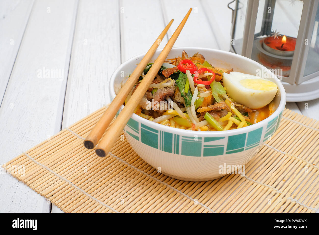 Malay Mee Rebus in the bowl with chopsticks on white table This dish is ...
