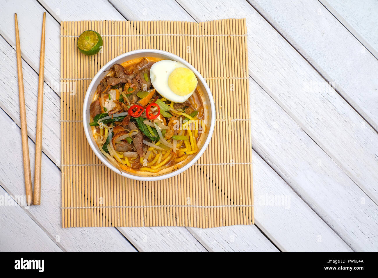 Malay Mee Rebus in the bowl with chopsticks on white table This dish is ...