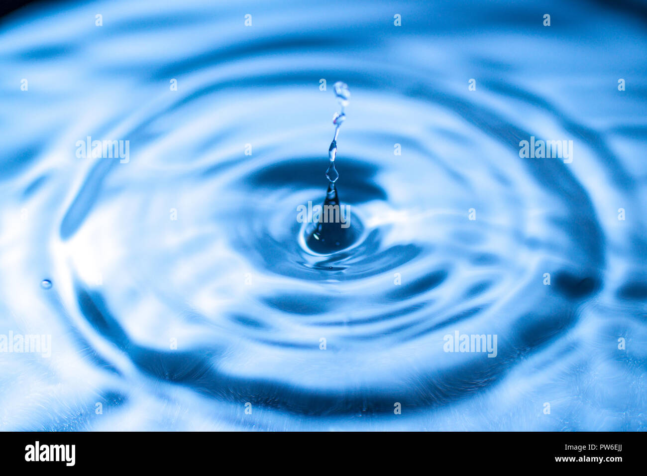 water drop splash in a glass blue colored Stock Photo - Alamy