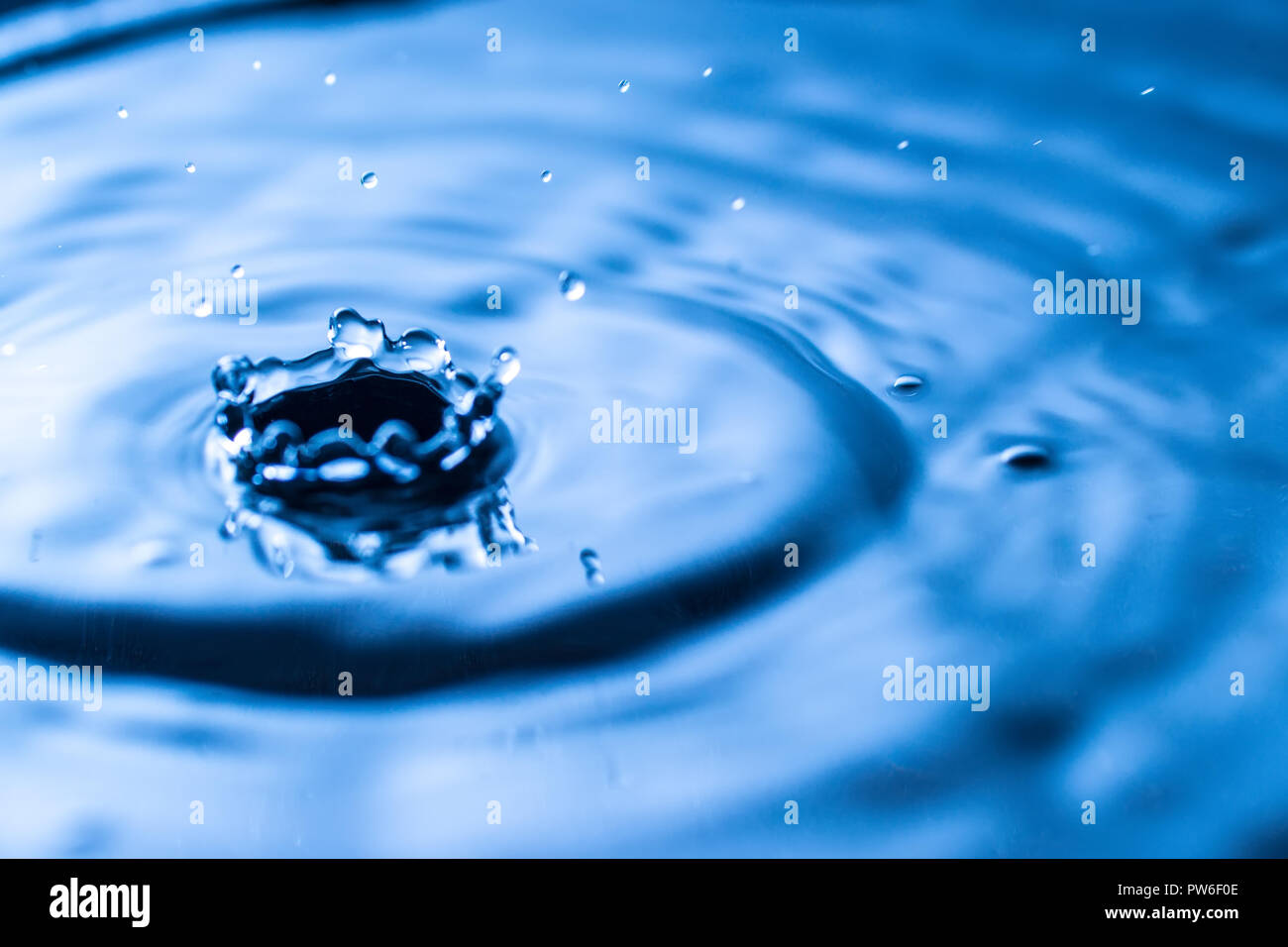 water drop splash in a glass blue colored Stock Photo - Alamy