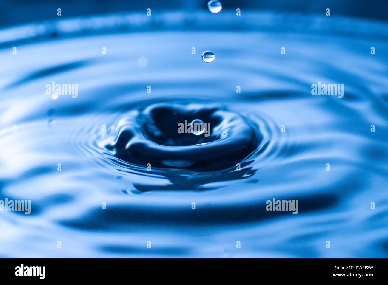 water drop splash in a glass blue colored Stock Photo - Alamy