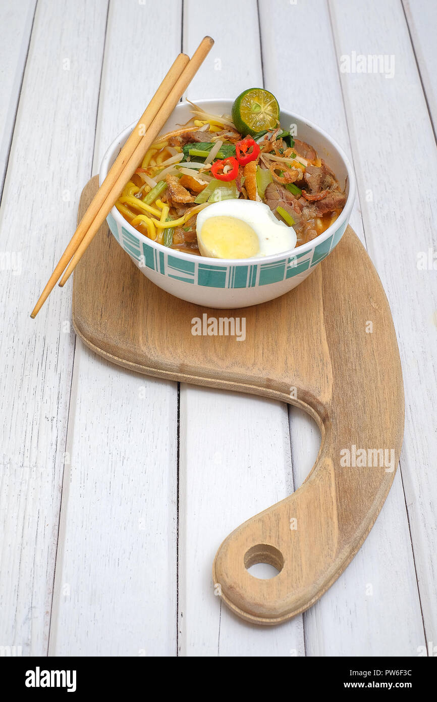 Mee Rebus in the bowl with chopsticks on white table This dish is made ...