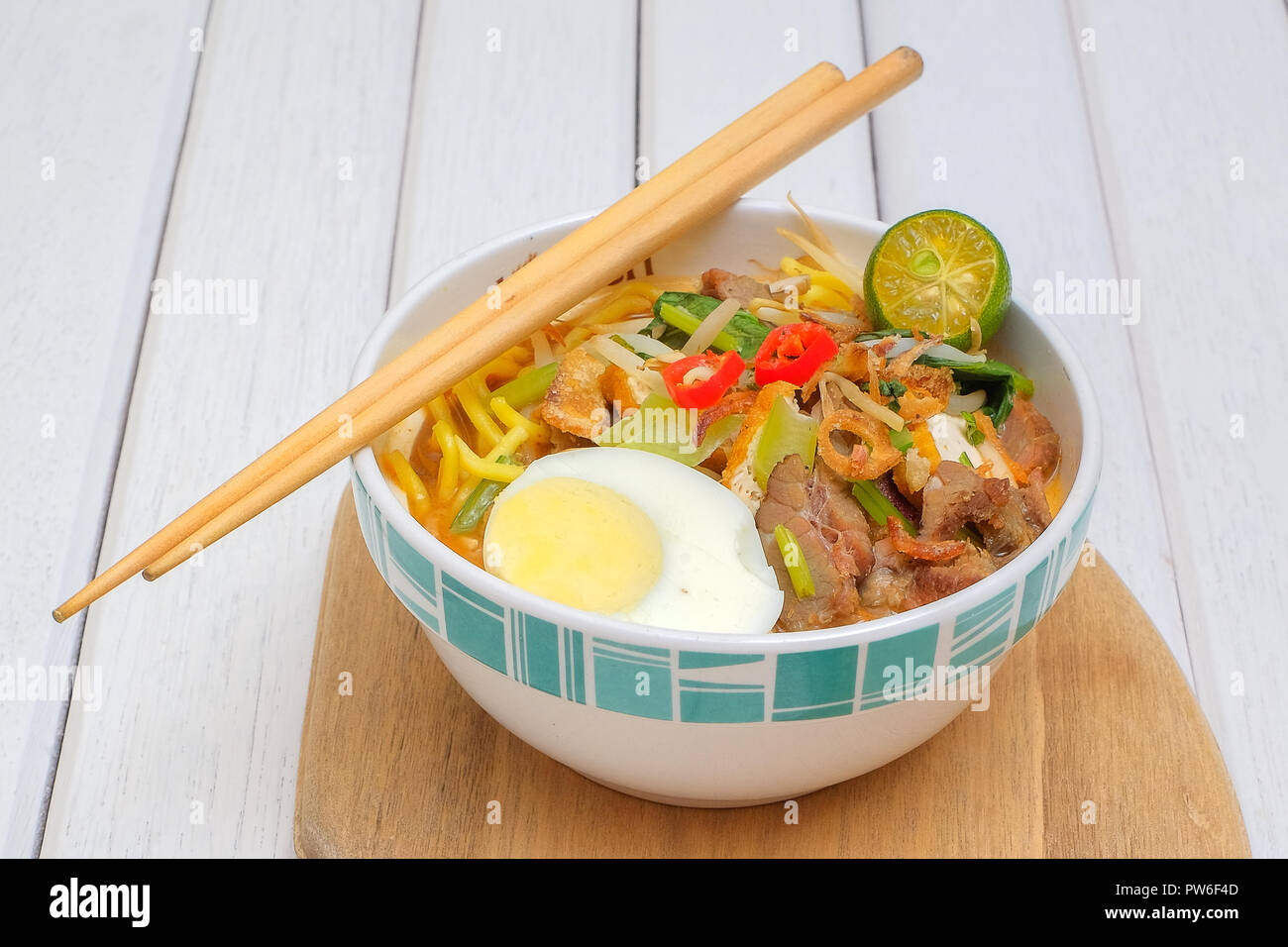 Mee Rebus in the bowl with chopsticks on white table This dish is made ...