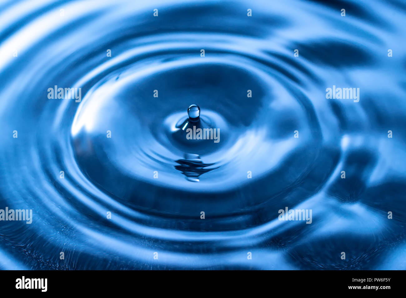 water drop splash in a glass blue colored Stock Photo - Alamy