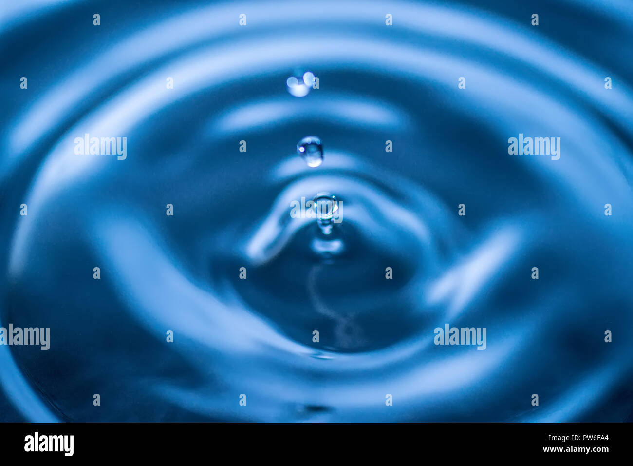 water drop splash in a glass blue colored Stock Photo - Alamy
