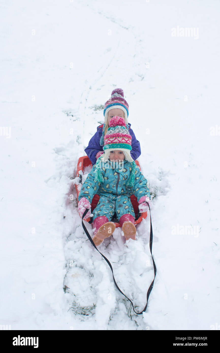 Children playing in the snow on a sledge Stock Photo - Alamy