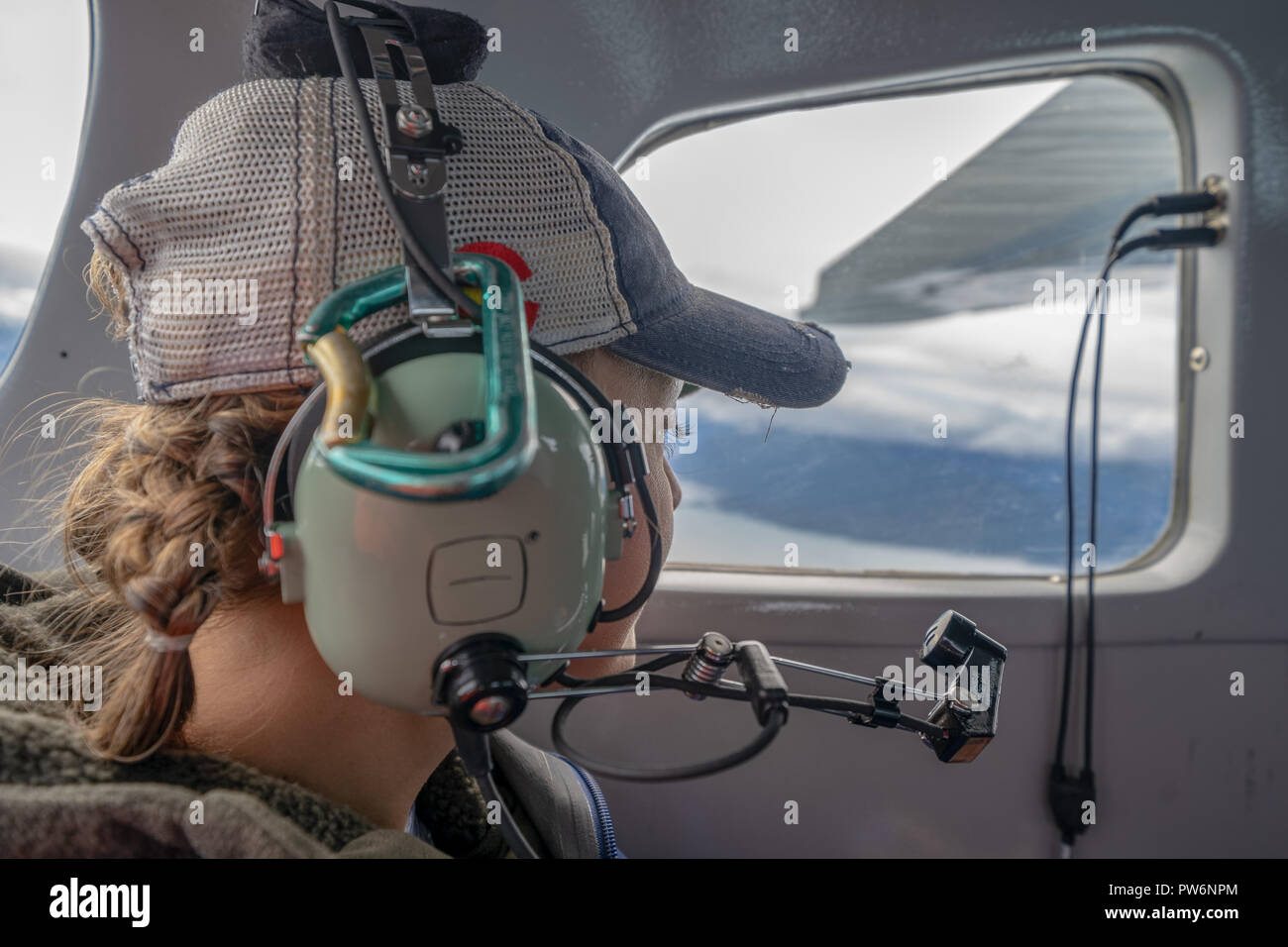 Female passenger looks out the window while flying in an Alaskan Bush ...