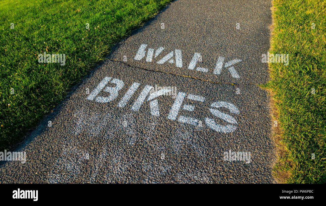 white sign stenciled painted asphalt walkway with grass sides Stock ...