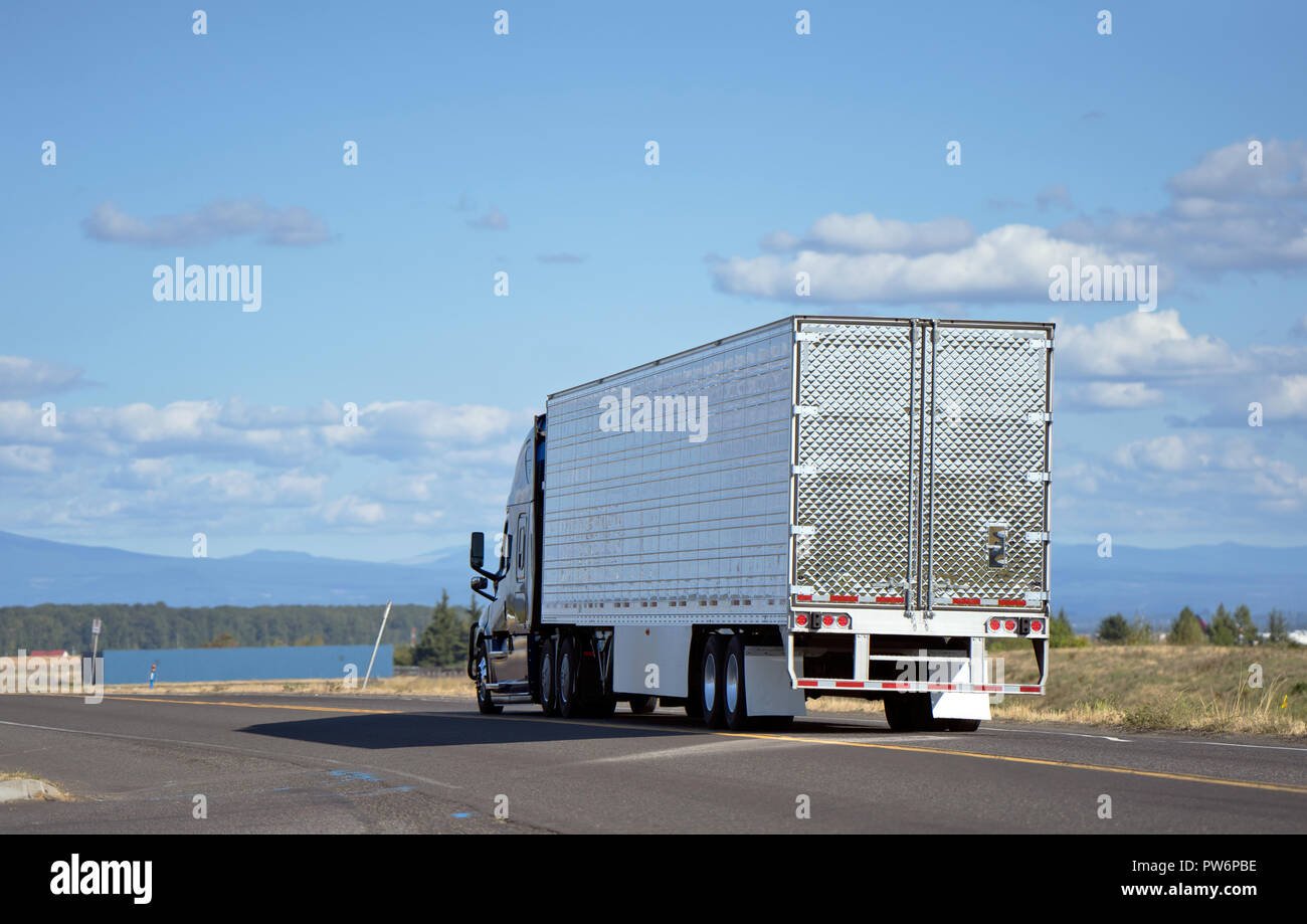 Dark big rig modern professional popular semi truck transporting ...