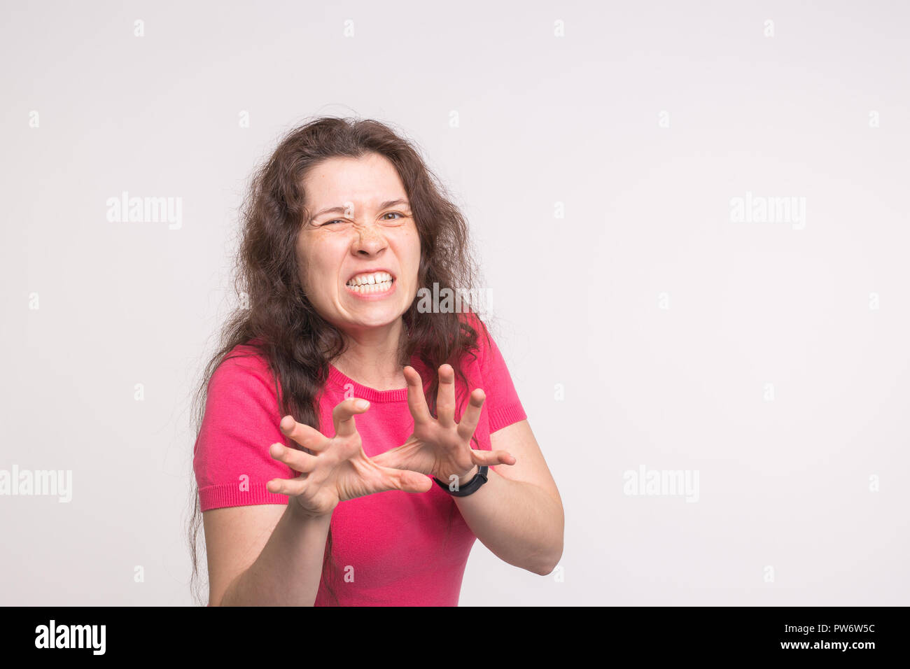 Portrait of a frustrated angry woman on white background with copy ...