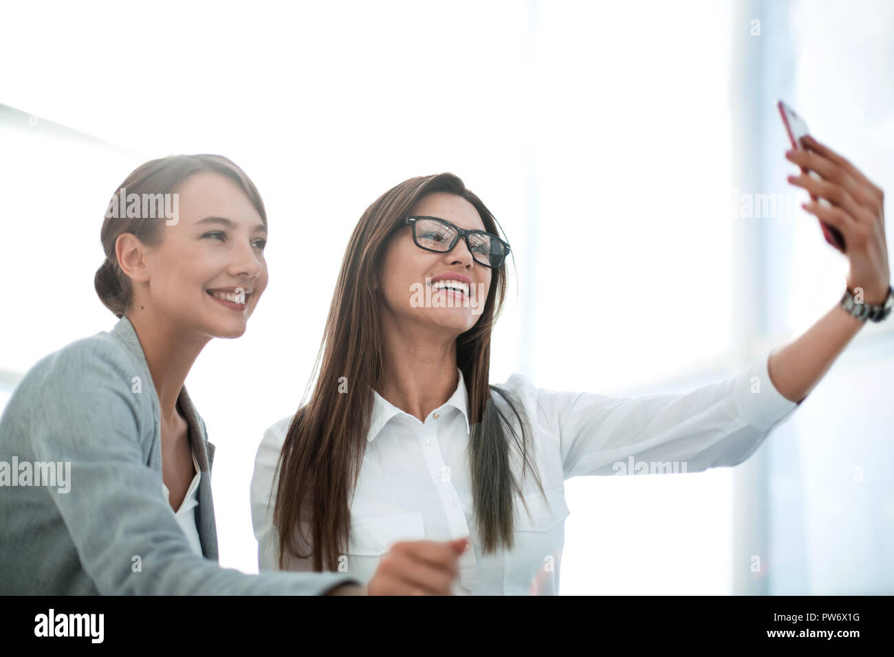 two employees taking a selfie in the workplace Stock Photo - Alamy