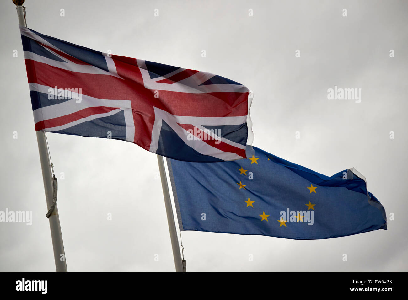 british uk union flag and eu flag flying in dark stormy sky england uk ...