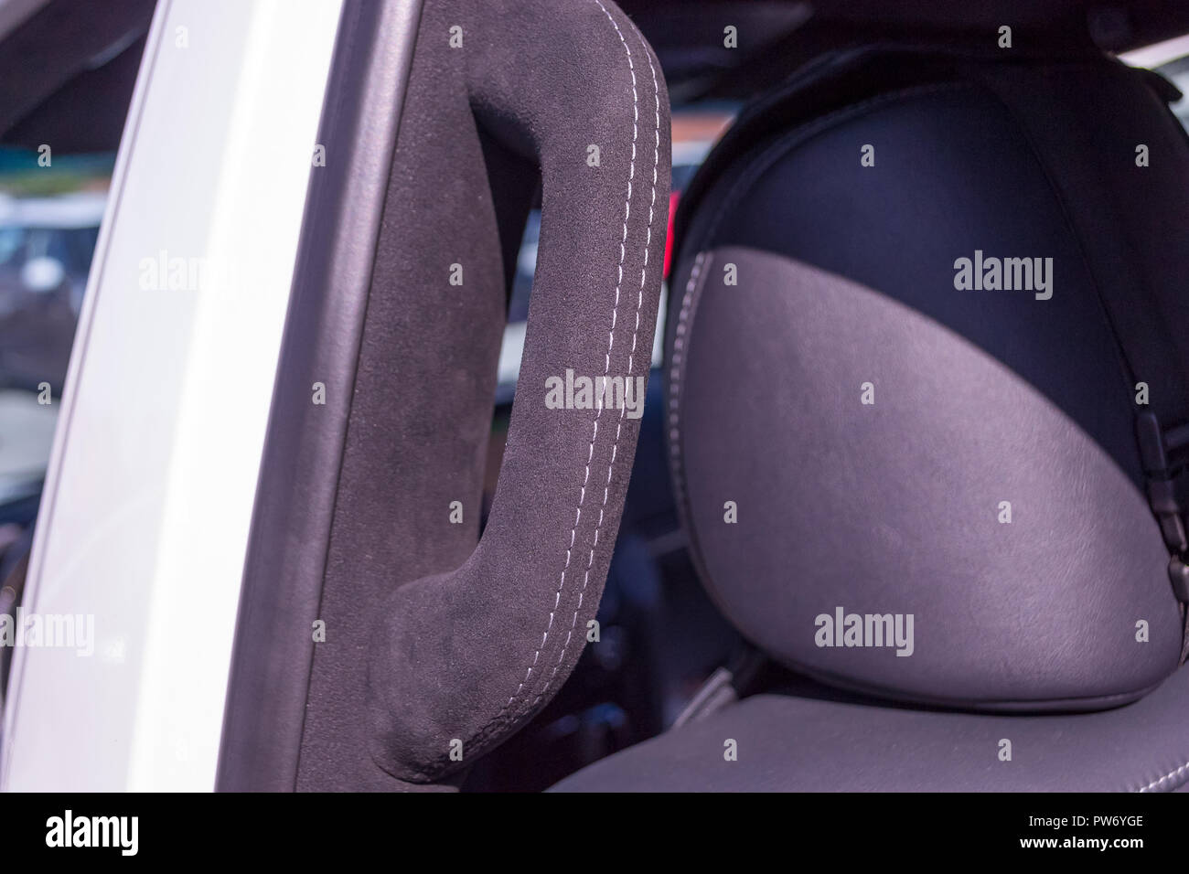 A close-up view of a black plastic handle on the ceiling in a car in a ...