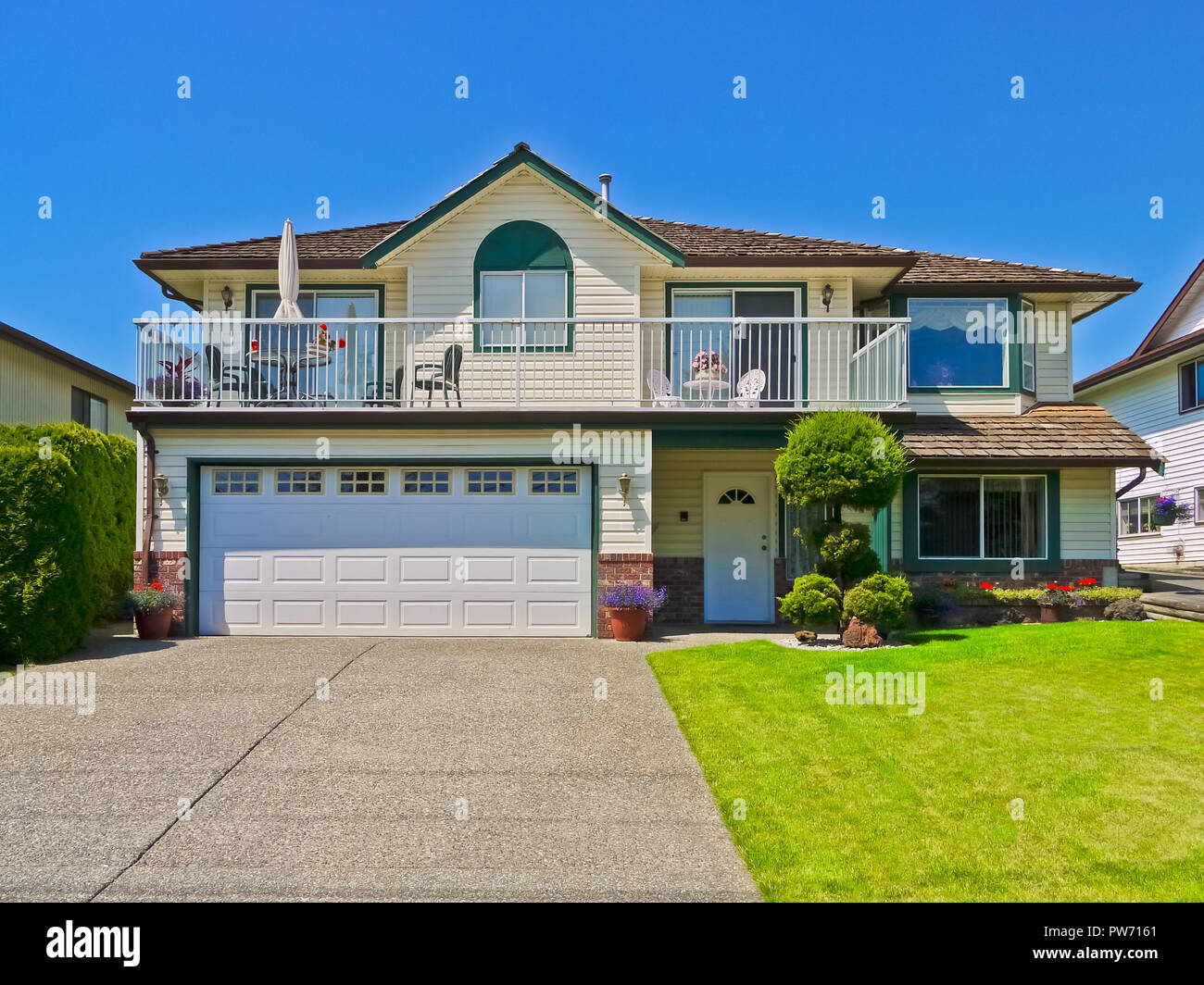 Average residential house with wide garage and concrete driveway on ...