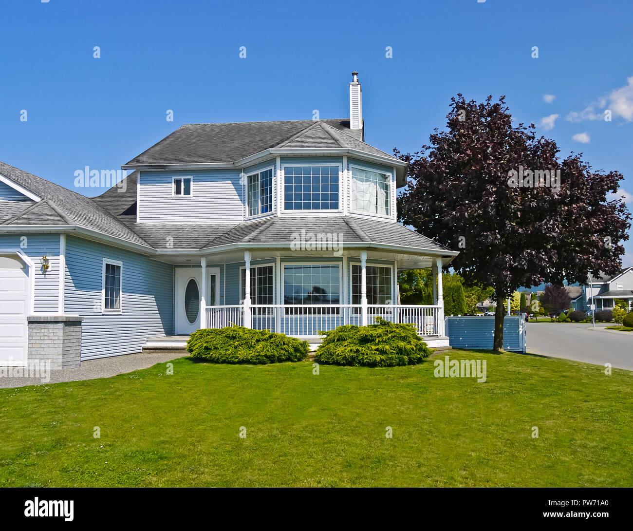 Large residential house with surrounding porch and big green lawn at ...
