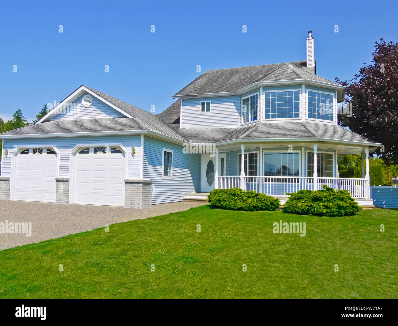 Large residential house with surrounding porch and big green lawn at ...