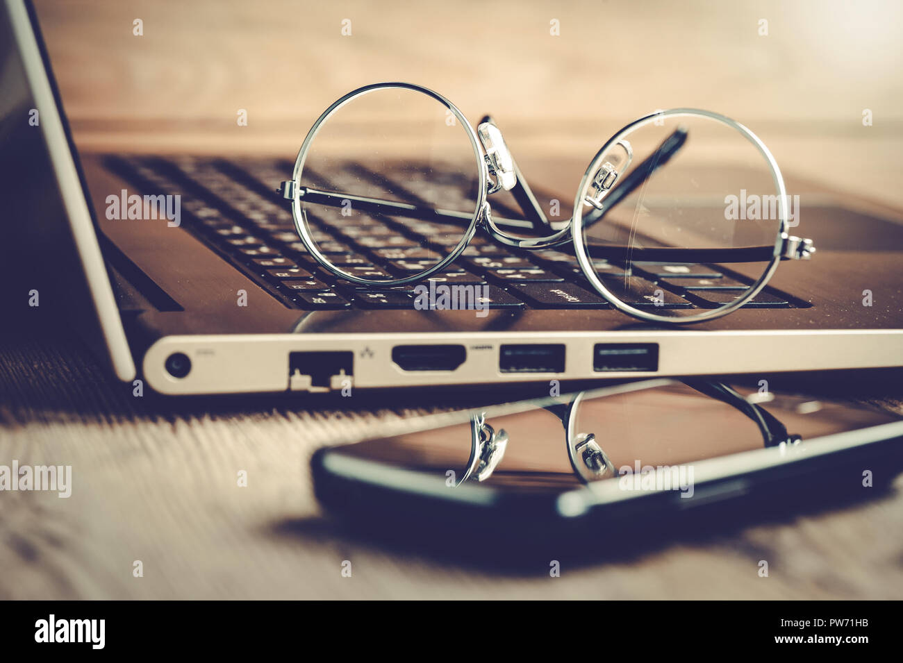 closeup round frame style of eyeglasses on wooden desk, shallow depth ...