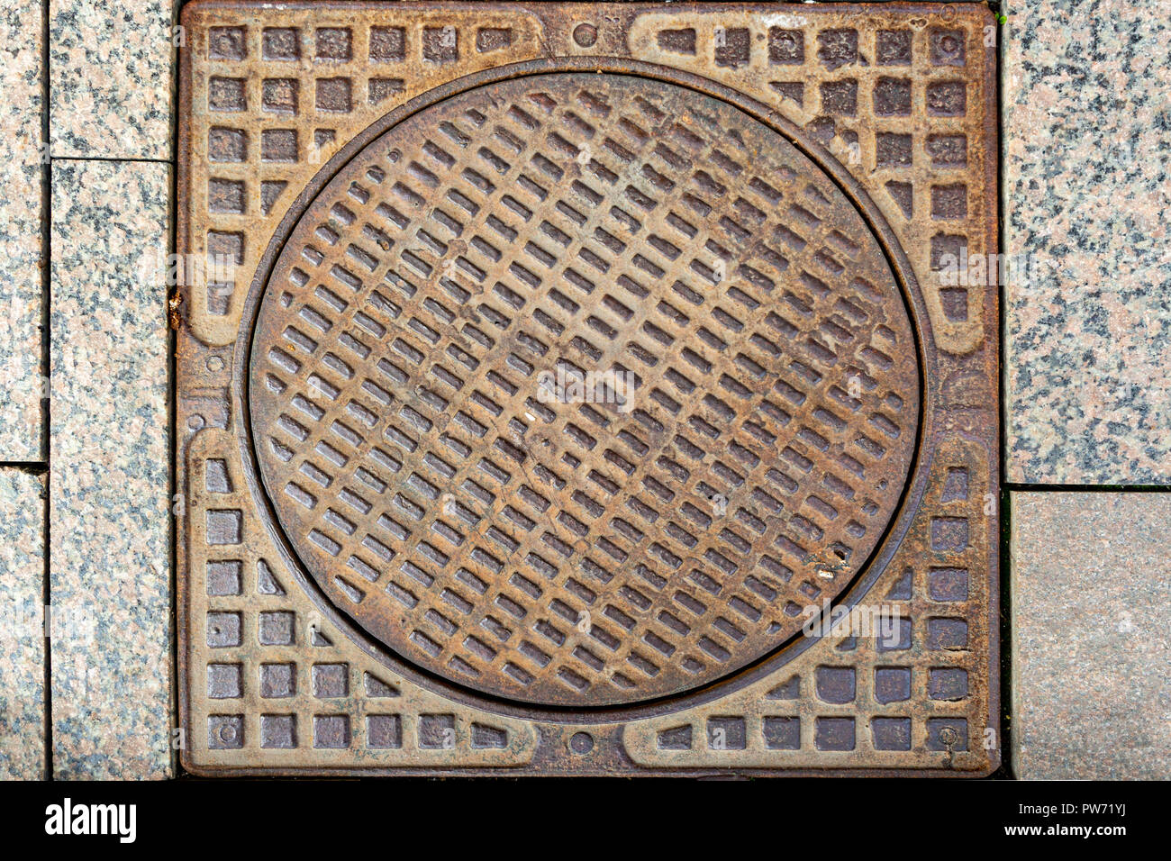 Old rusty sewer hatch on an old metal plate. View from above Stock ...