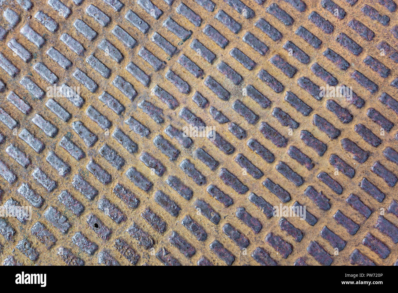 extremely close up view of old rusty sewer hatch on an old metal plate ...