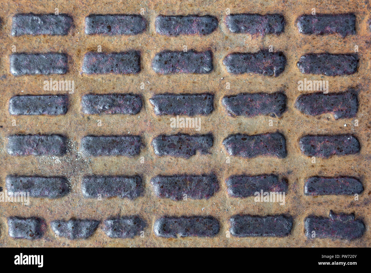 extremely close up view of old rusty sewer hatch on an old metal plate ...
