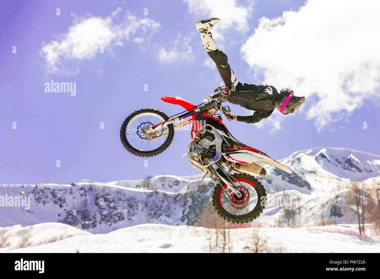racer on a motorcycle in flight, jumps and takes off on a springboard ...