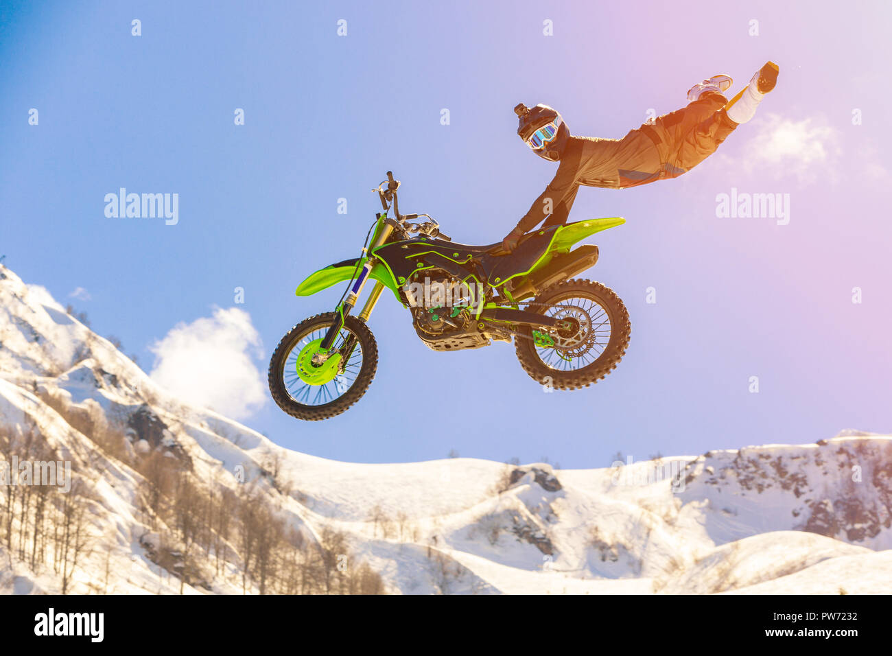 racer on a motorcycle in flight, jumps and takes off on a springboard ...