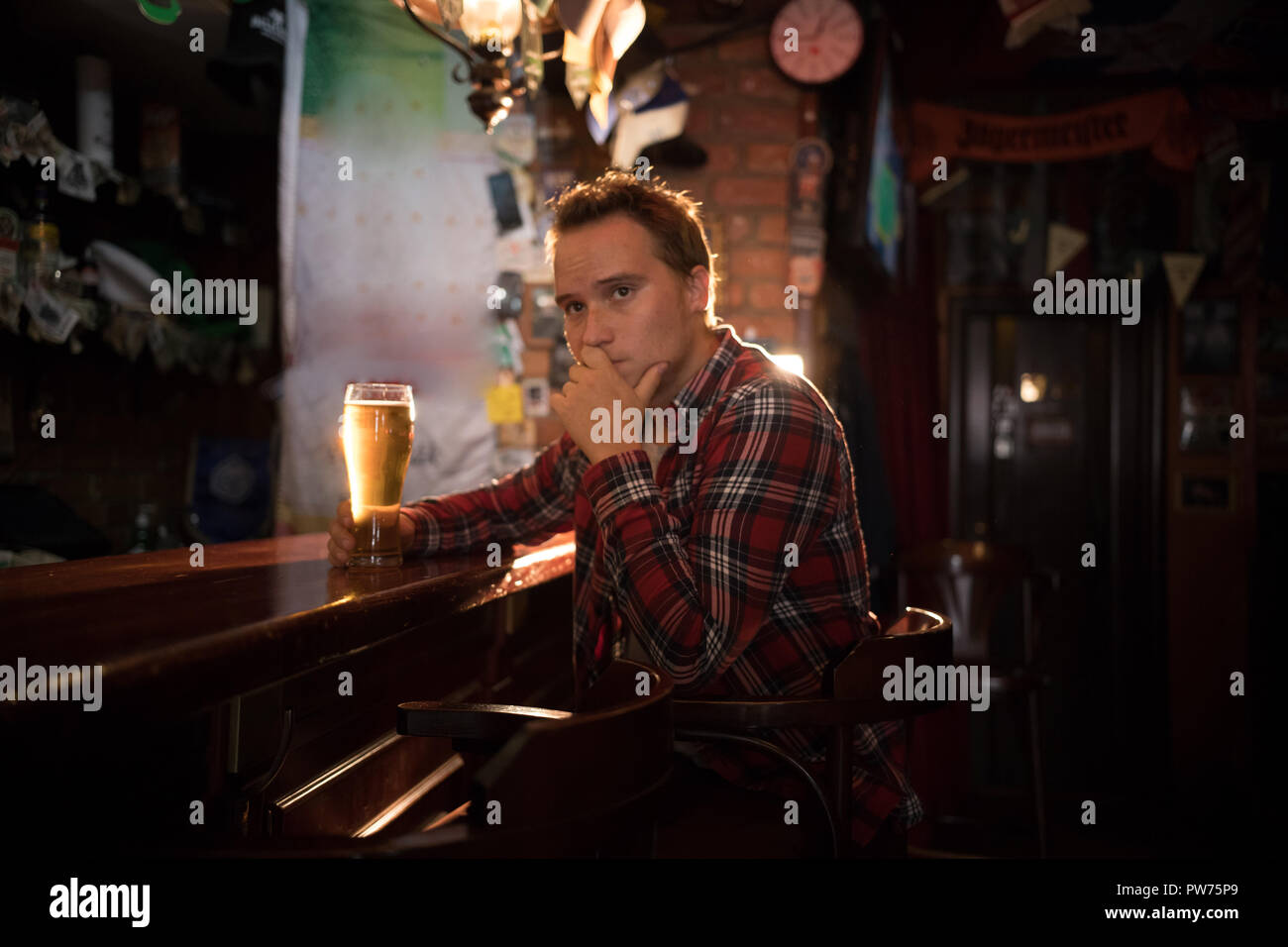 Thoughtful young man drinking beer at the bar in irish pub Stock Photo ...
