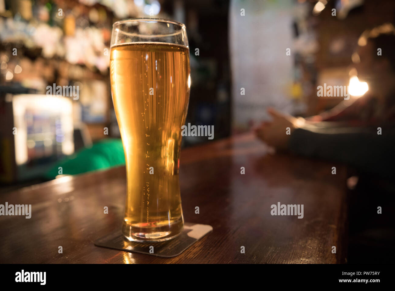 Guy friends drinking beer on the background. Full pint of beer in focus ...